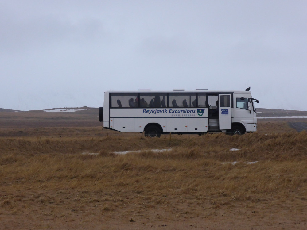 A Reykjavik Excursions bus parked on Snæfellsnes, with a grey winter ...