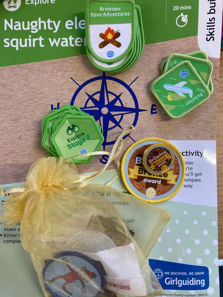 A green Unit Meeting Activity card with badges piled on it – a little ...